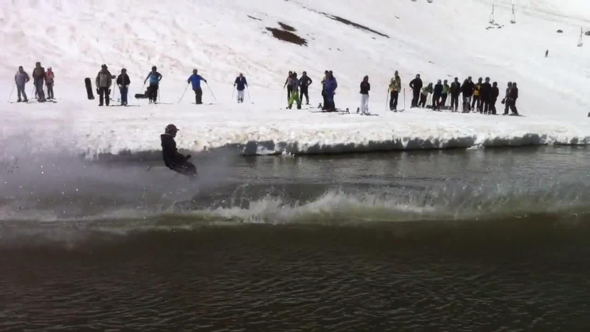 Two Guys Try to Skim Across Pond on Skis and Snowboard | Jukin Media Inc