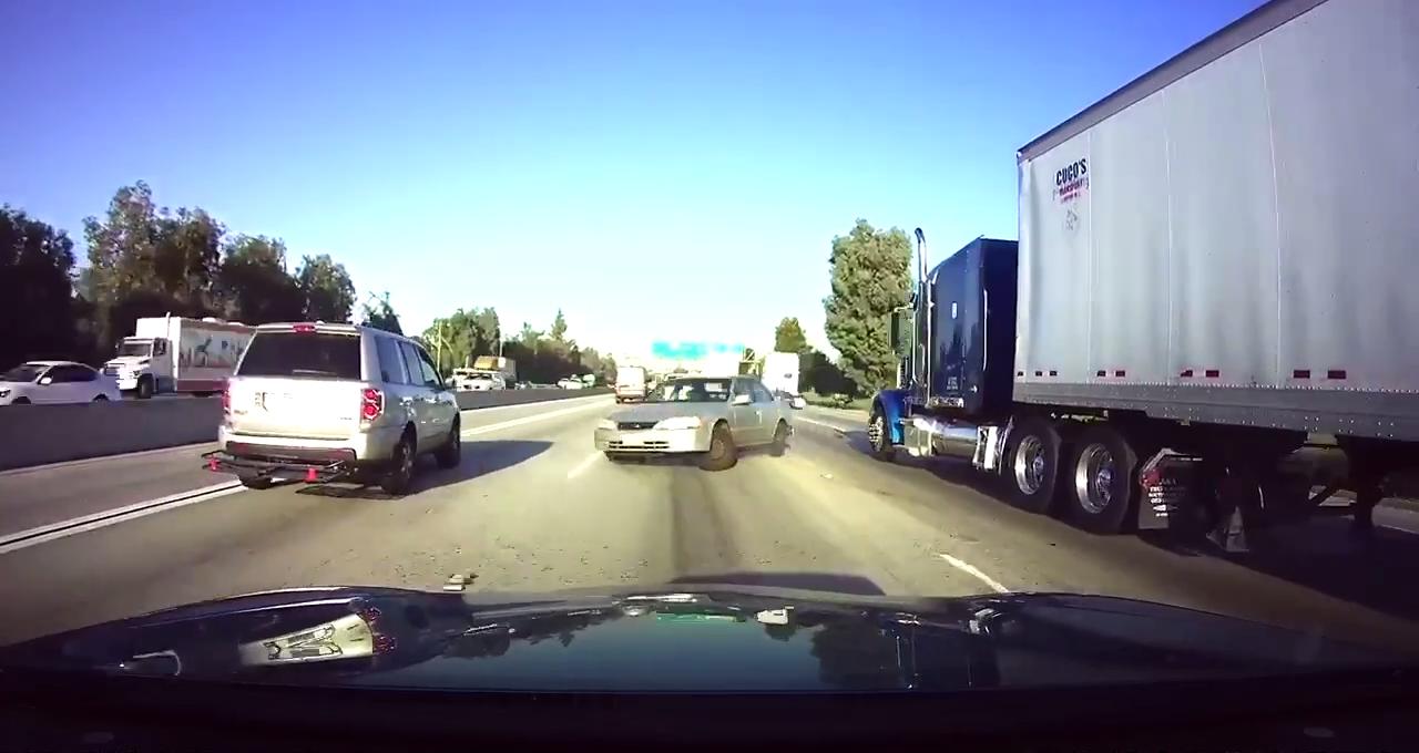 Motorcyclist Crashes and Slides Between Wheels of Semi | Jukin Media Inc