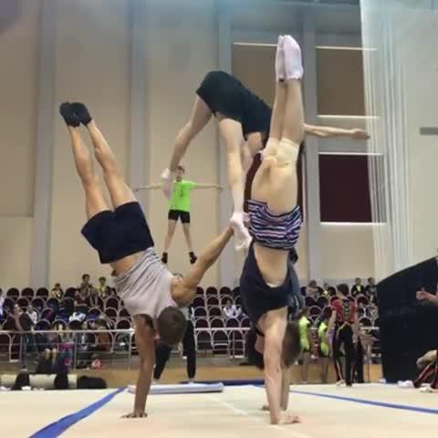 Acrobats Perform Two Person Headstand on Moving Walkway | Jukin Media Inc