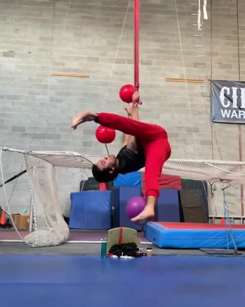 Acrobat Hangs to Aerial Strap Balancing Three Balls Together | Jukin ...