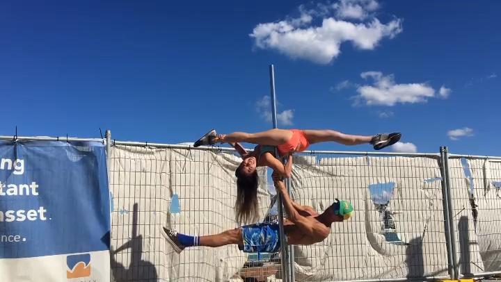 Duo Poses While Hanging on Pole Horizontally | Jukin Licensing