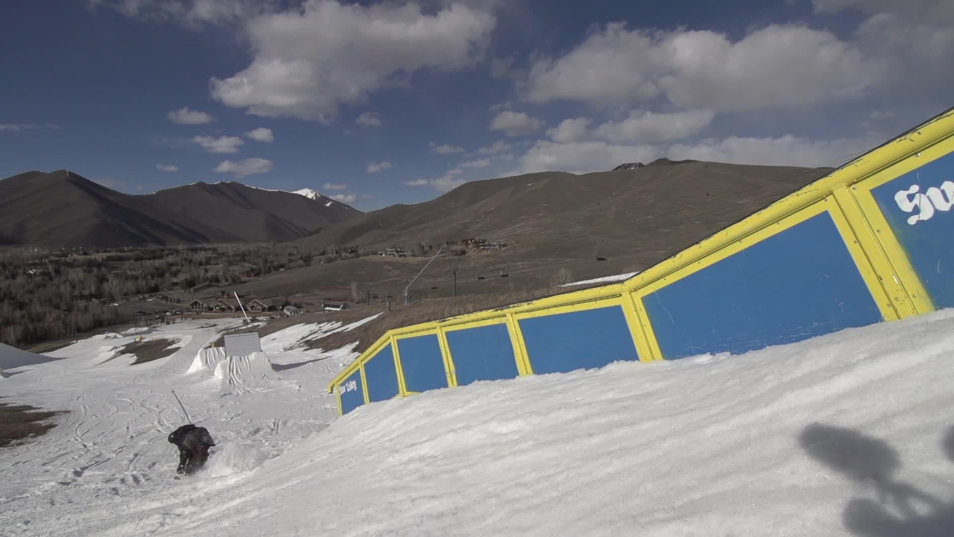 Skier Slides on Snowy Slope After Falling off Rail While Skiing on it ...
