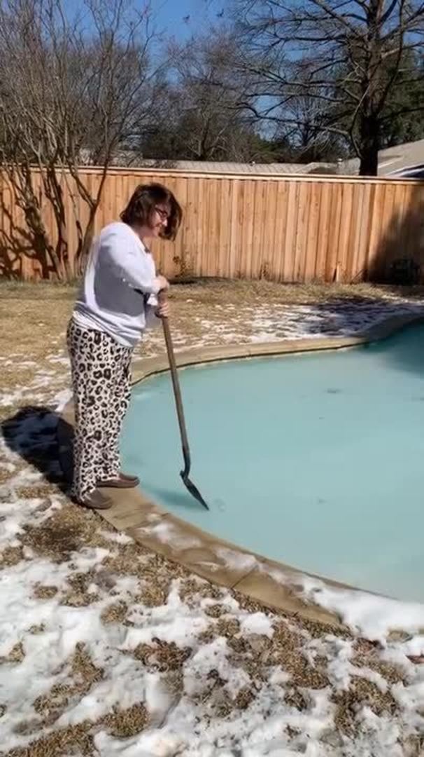 Woman Falls in Icy Cold Water as She Prods Frozen Pool with Shovel ...