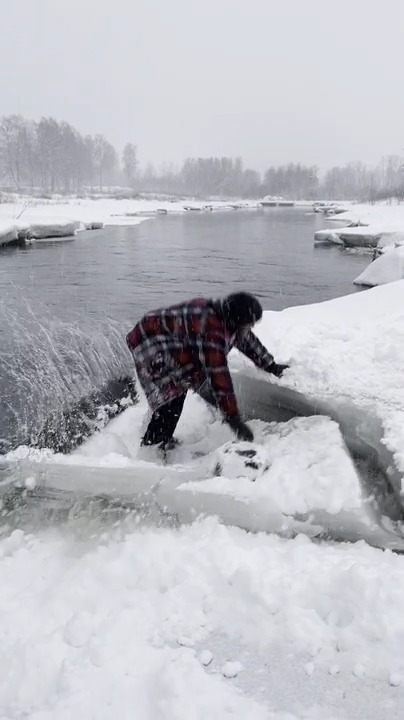 Man Attempts To Break Ice Block Using a Rock But Falls Into Water ...