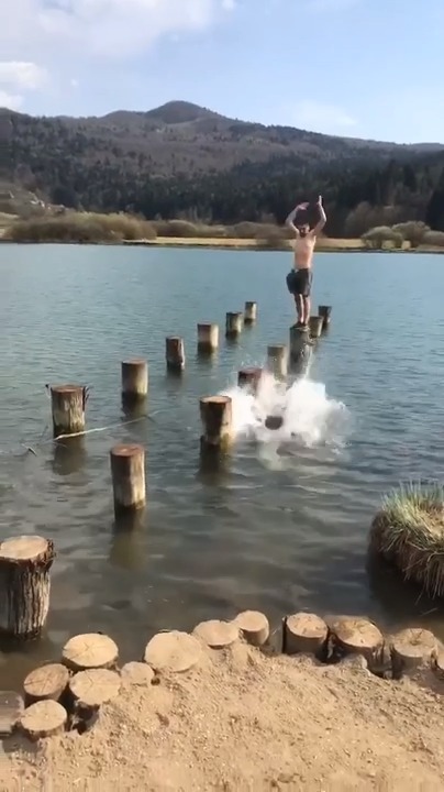Guy Falls in Water While Attempting to Jump From One Vertical Log of ...