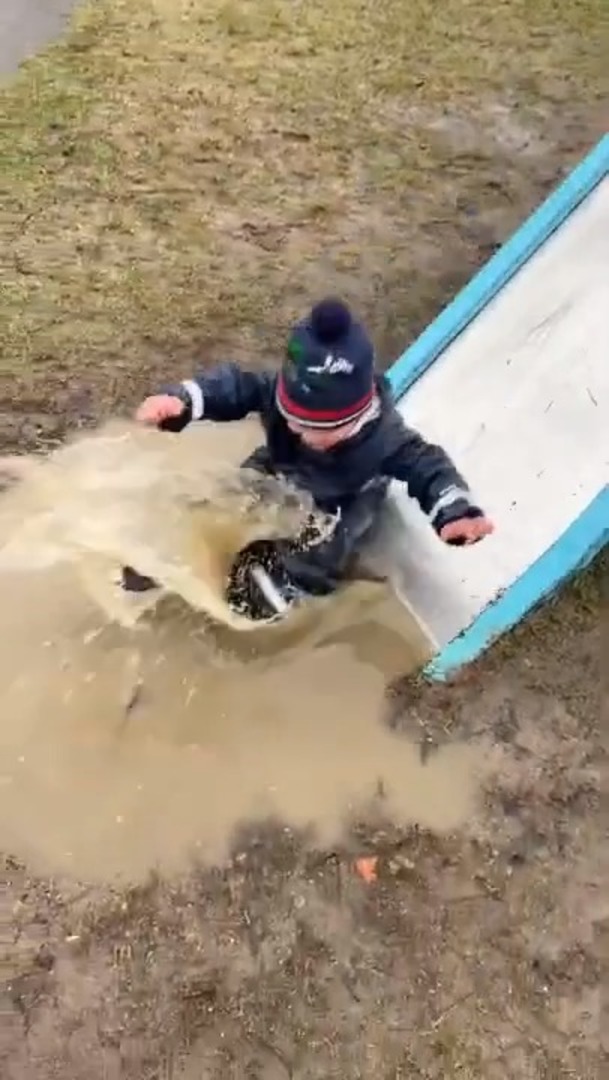 Toddler Slides down Playground Slide and Splashes Into Muddy Puddle ...