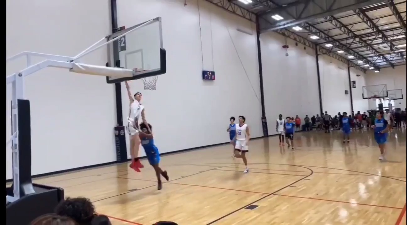 One Player Jumps Over Another And Dunks Ball in Basket While Basketball ...