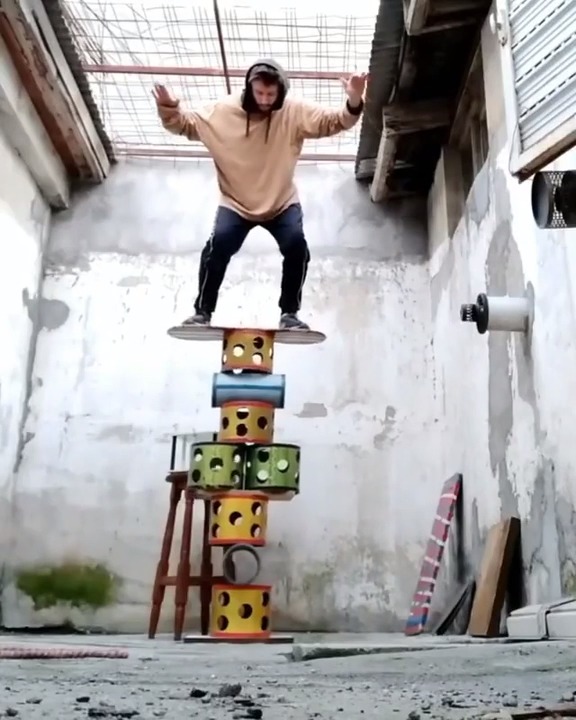 Circus Performer Balances on Multiple Cylinders Below Balance Board ...