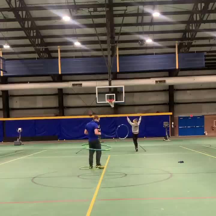 Man Shows Trick By Throwing Ball Through a Hoop While Hula Hooping ...