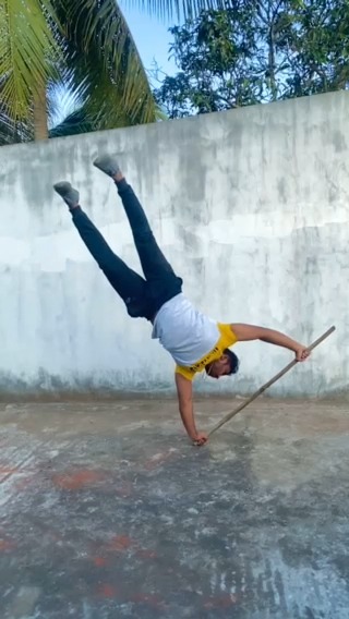 Guy Balances Himself on Tilted Stick After Vertically Pinning it to ...