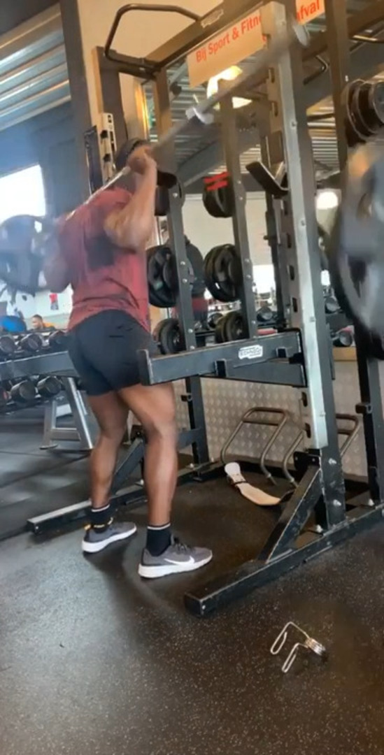 Weights From Barbell Fall Off as Guy Does Squats While Lifting it ...