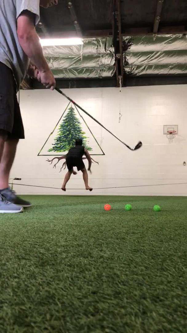 Man Balances on Rope and Catches Golf Ball Shot by Another Person ...