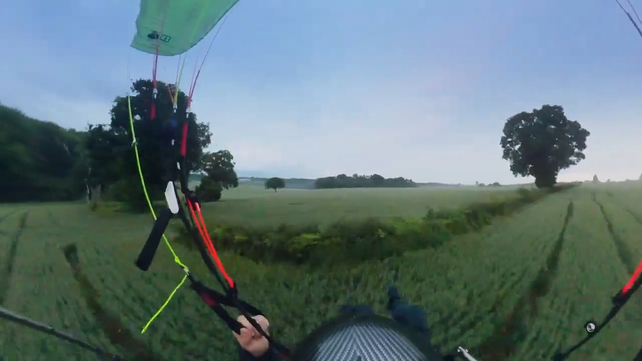 Guy Flies Paraglider Close to the Ground and Between Trees in Wide Open ...
