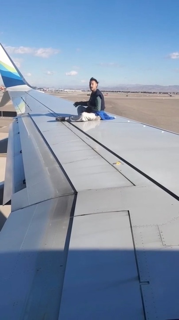 Man Climbs on Plane Wing While on Airport Runway | Jukin Licensing