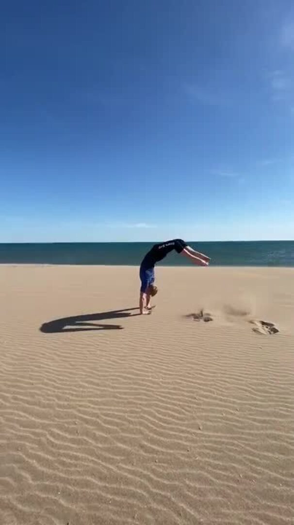 Person Performs Multiple Flips on Picturesque Beach | Jukin Licensing