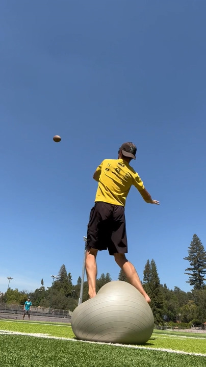 Guy Practices Balancing Skill by Standing on Yoga Ball and Playing ...
