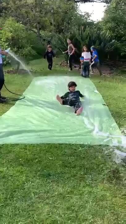 Girl Crashes Into Little Boy While Playing on Soap Slide | Jukin Licensing