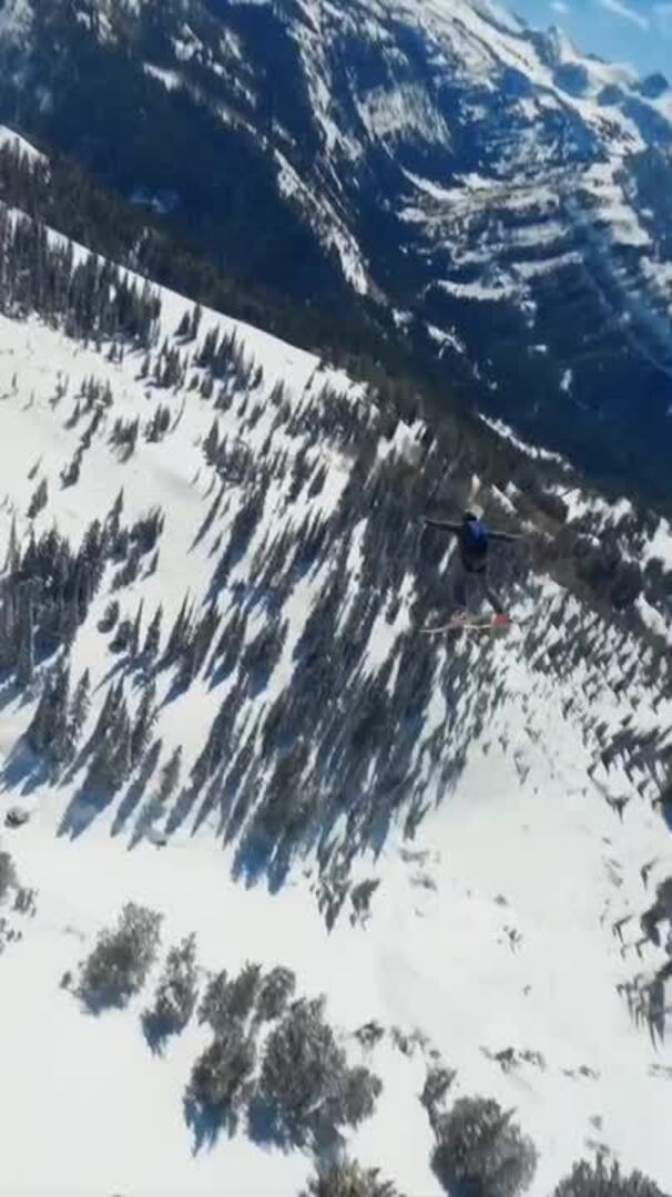Person Does Parachute Jump While Skiing Downhill on Cliff | Jukin Licensing