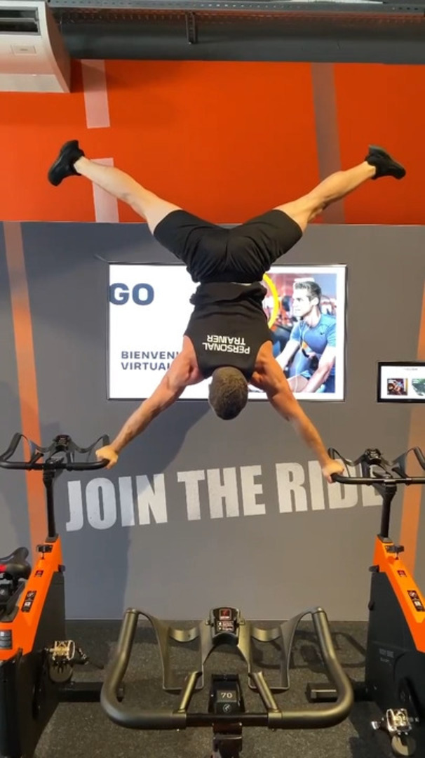 Guy Executes Handstand and V-sit on Stationary Bike | Jukin Licensing