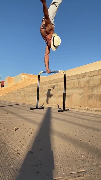 Person Rotates on Metal Frame While Doing Single-Handed Handstand ...