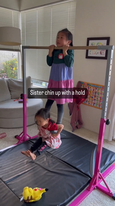 Little Girl Does Hanging Chin Up Trick While Her Sister Hangs From Her ...