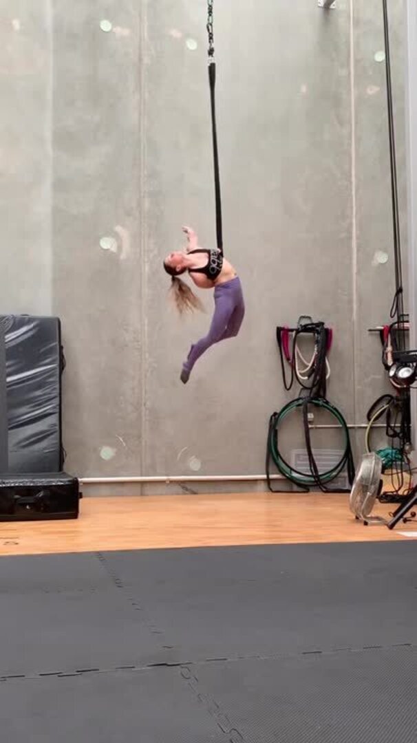 Woman Performs Acrobatic Workouts While Holding Onto Aerial Straps With ...