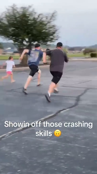 Man Loses Footing and Falls While Racing Across Parking Lot With Fellow ...