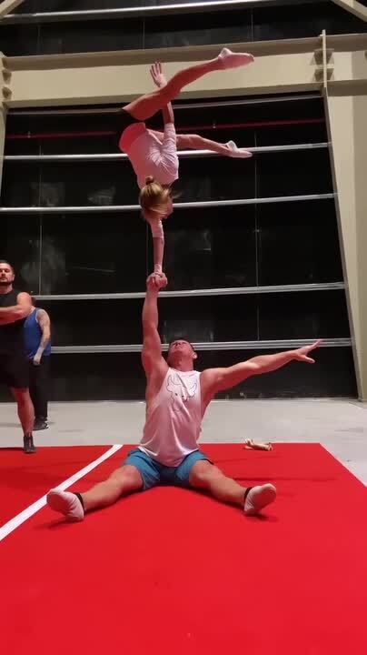 Woman Flawlessly Executes Mid-Air One Arm Handstand on Partner's Hand ...