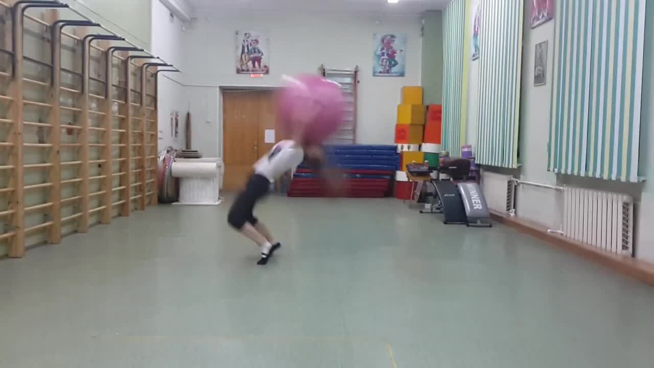 Girl Holding Exercise Ball Does Backflips | Jukin Licensing