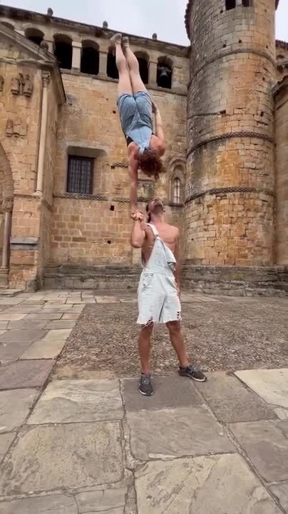 Woman Walks And Does Handstand on Partner's Hands While Performing ...