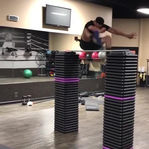 Guy Performs Extremely High Jump Over Tall Stacks of Workout Equipments ...