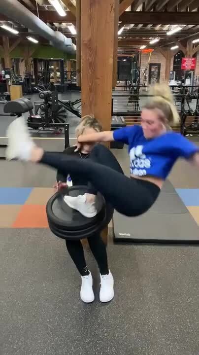 Woman Tries One-Legged Jump on Weight Plates Stacked on Person's Lap ...