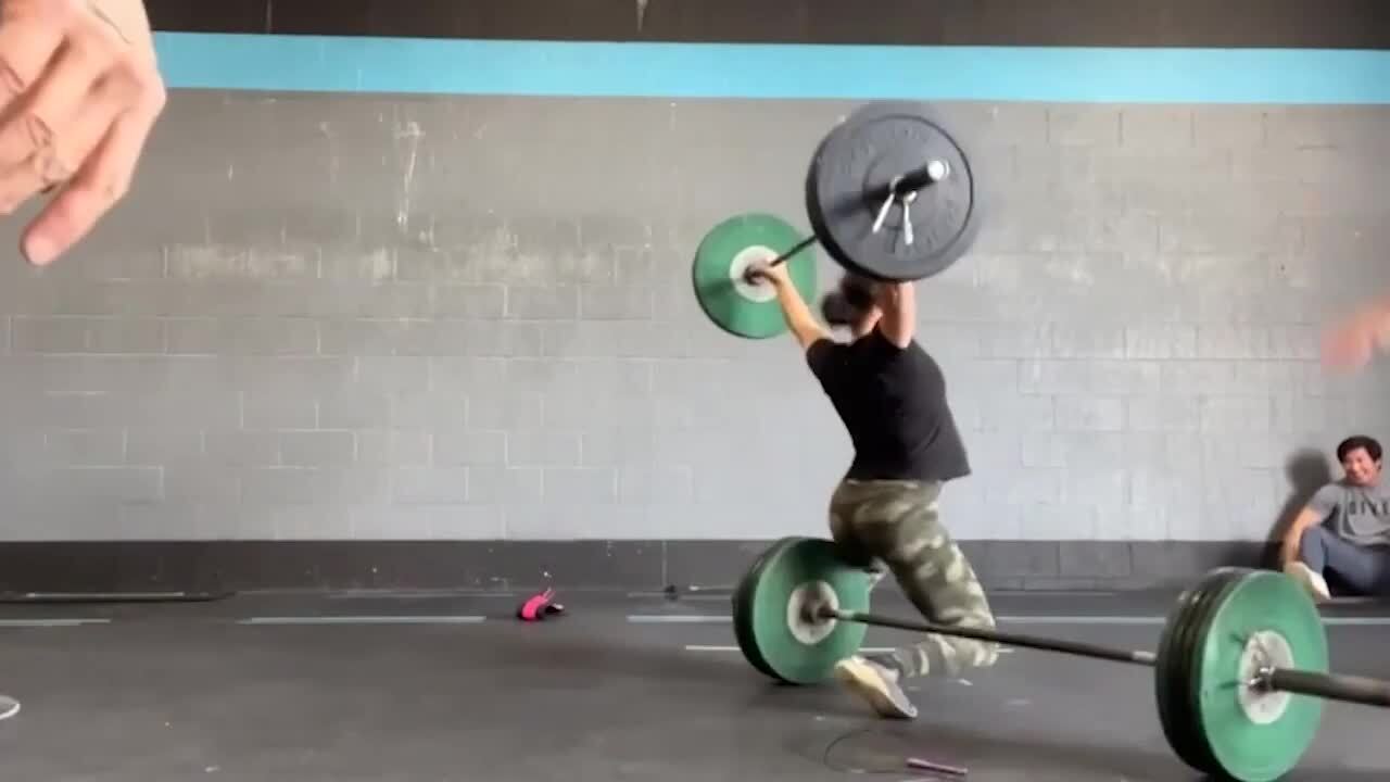Barbell Rolls on Floor and Hits Woman From Behind While She Does ...