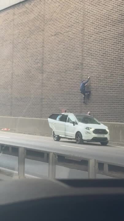 Police Surround Man Climbing Wall to Escape by Roadside | Jukin Licensing